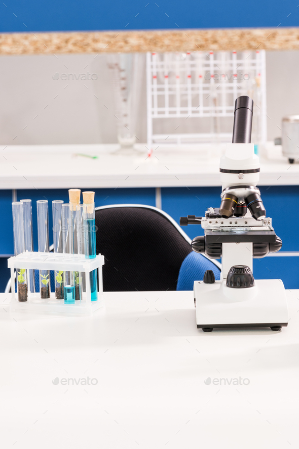 tubes and microscope standing on table in empty chemical laboratory ...