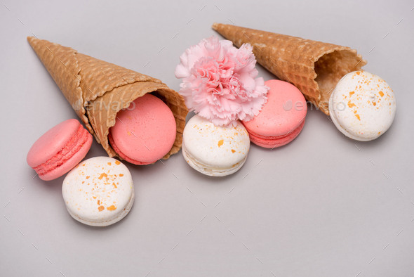 Group of pink and white macarons in waffle cones with Carnation flower ...