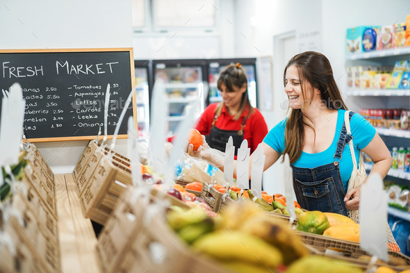 Female customer buying organic food fruits inside eco fresh market ...