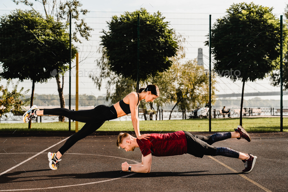 Sporty young fit couple exercising together on sporting ground Stock ...