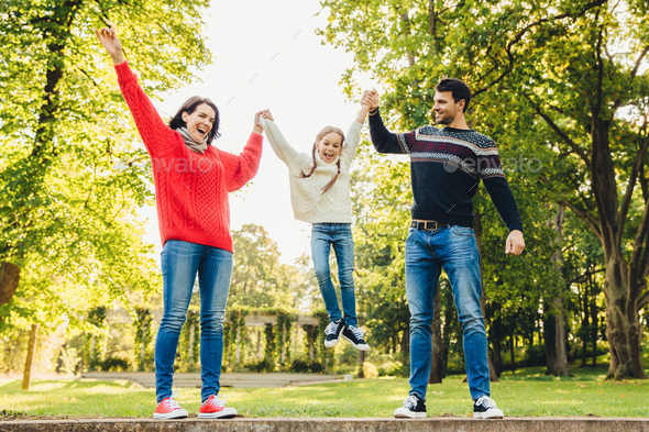 Funny playful child rocks in parent`s hands, being overjoyed. Stock ...