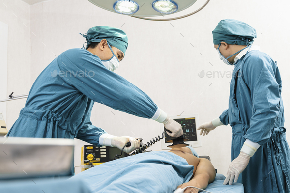 surgeon and assistant making CPR on the patient in operating room ...