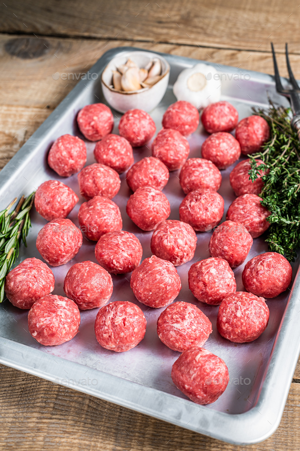 Uncooked Raw beef and pork meatballs with thyme and rosemary in kitchen ...