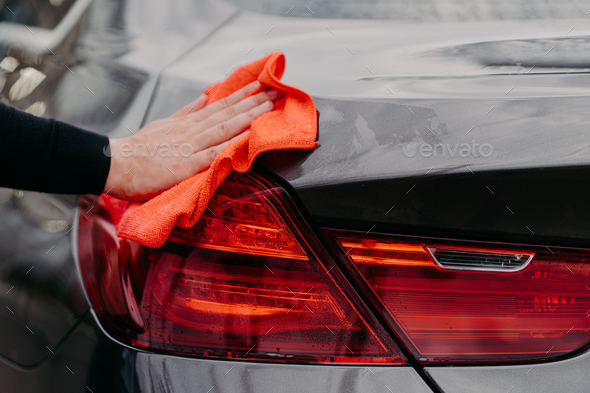 Cleaning auto concept. Mans hand wiping car hood with microfiber cloth ...
