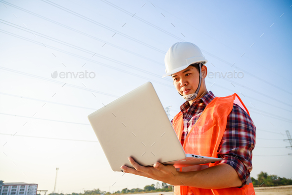 Asian engineer manager using computer laptop at construction site ...
