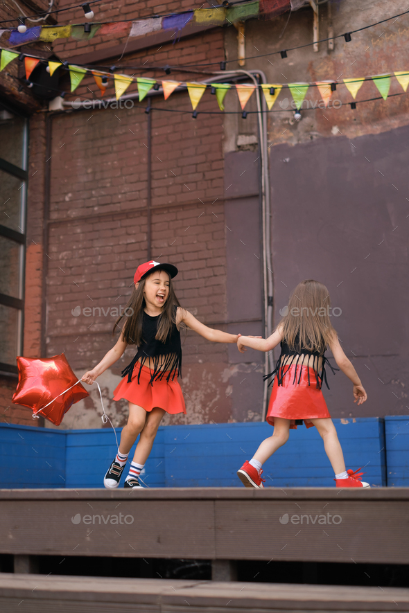 Girlfriend run and spin on city scene decorated with garland of flags ...