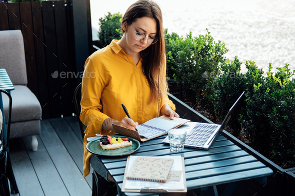 Woman numerologist working with numbers in notepad and laptop ...