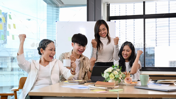 Excited business people celebrating corporate achievement at meeting ...