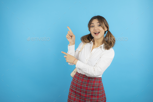 Smiling college girl pointing fingers to the left side Stock Photo by ...