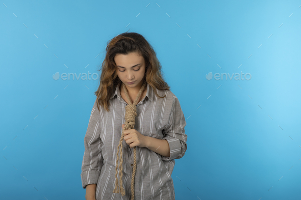 Depressed young girl put rope around her neck and looking down Stock ...