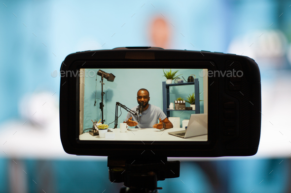Selective focus on back screen of dslr filming influencer sitting at ...