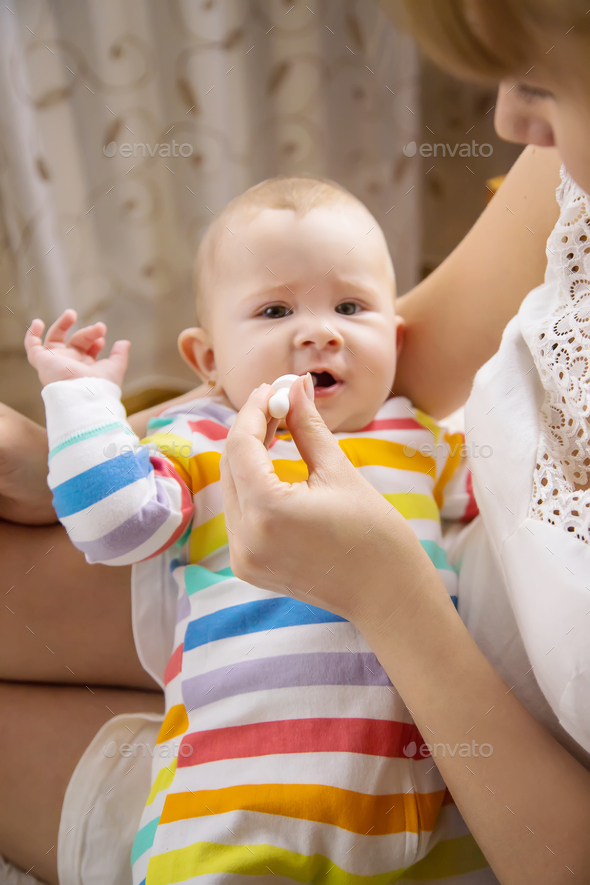 mother gives colic medicine to little baby. Selective focus. Stock ...