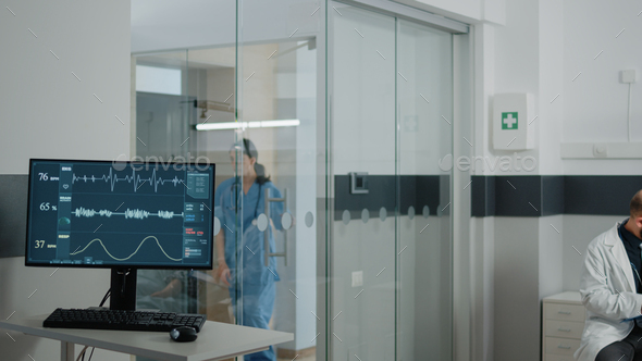Heart rate monitor at clinic measuring pulse while doctor doing checkup ...