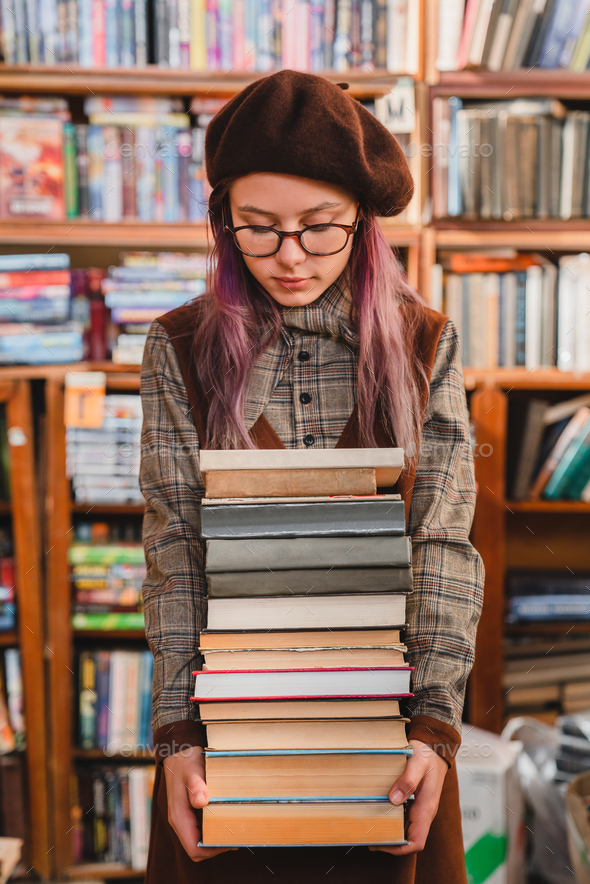 Young clever good-looking caucasian female student holding a stack of ...
