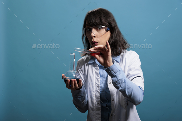 Laboratory worker expert carefully mixing liquid substances while ...
