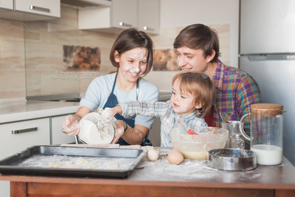 little child helping his parents with cooking at kitchen Stock Photo by ...