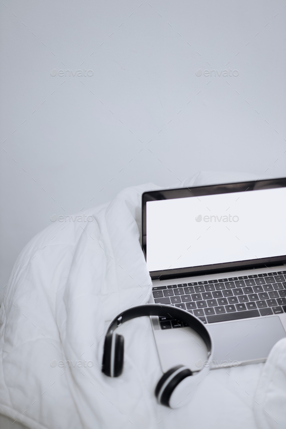 Placeit - Laptop with blank screen on bed Stock Photo by Garakta-Studio