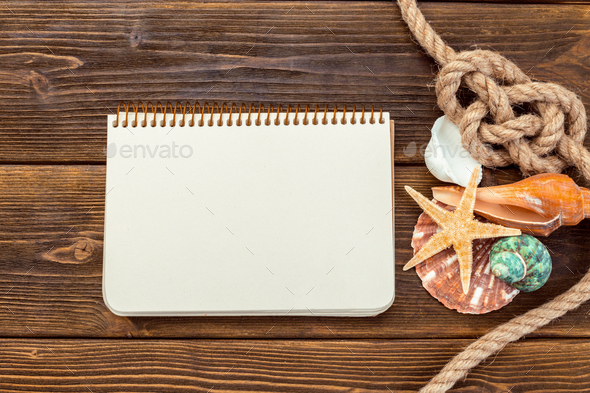 Shells and notepad on wooden table. Top view with copy space Stock ...