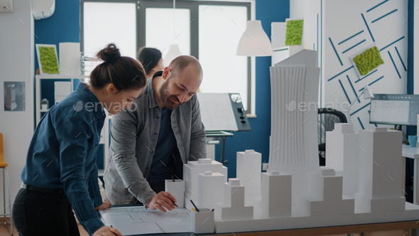 Team of colleagues using building model for inspiration to design ...