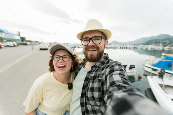 couple taking a self portrait laughing as they pose close together for ...
