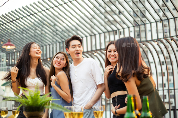Group of happy Asian girls and man celebrating party, dancing and drink ...