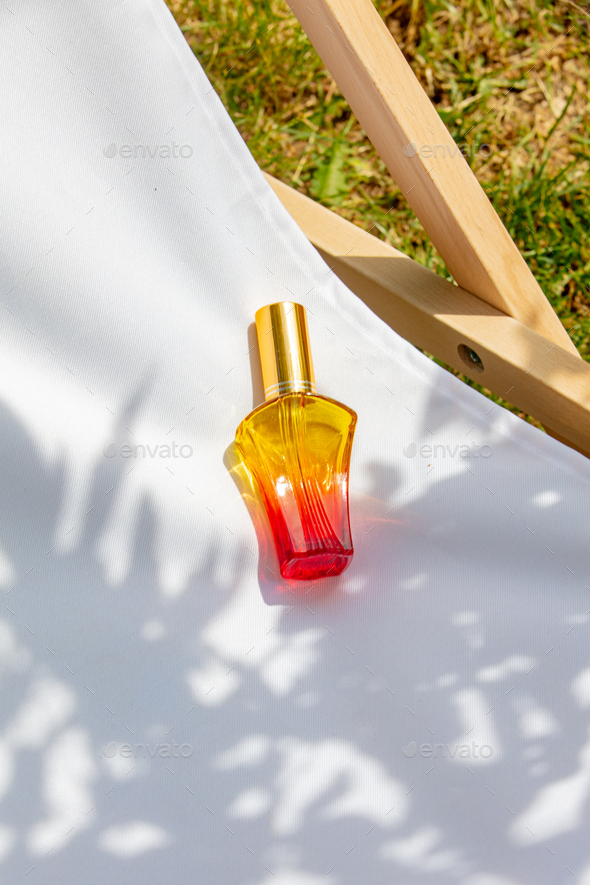 Perfume bottle on beach chair in shadow Stock Photo by Masson-Simon