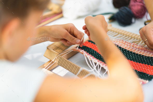 Girl weaving small rug with pattern at masterclass on weaving. Stock ...