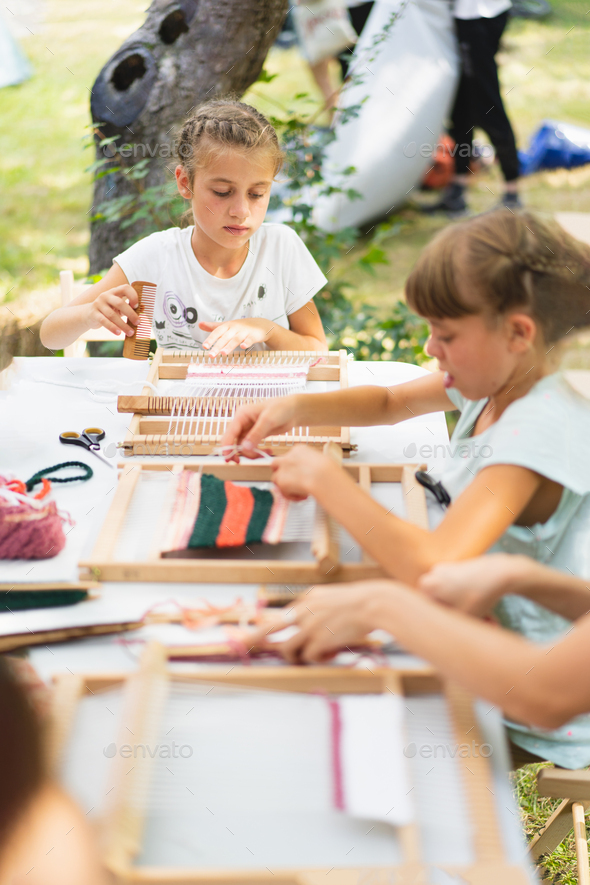 Girl weaving small rug with pattern at masterclass on weaving. Stock ...