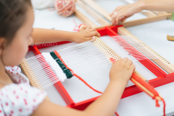 Girl weaving small rug with pattern at masterclass on weaving. Stock ...