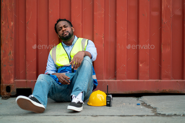 African American cargo container worker or technician sit and lean on ...