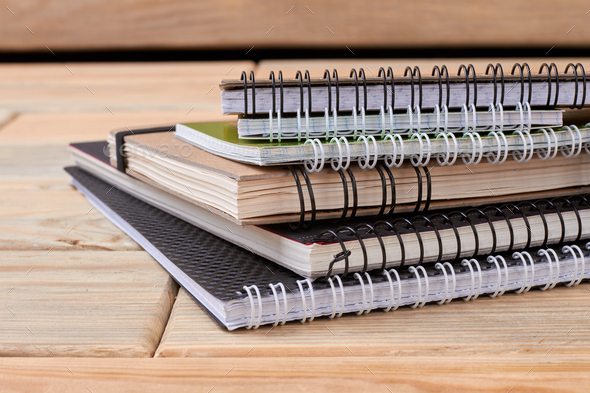 Stack of spiral notebooks on wooden background. Stock Photo by ...