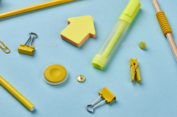 Yellow school supplies on blue background. Stock Photo by stockfilmstudio