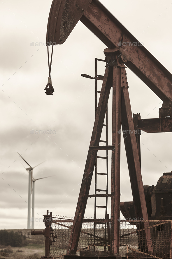 Oil pumping machine and windmills. Petroleum extraction. Resource Stock ...