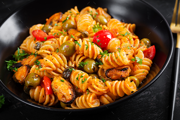 Classic italian pasta fusilli marinara with mussels, green olives and ...