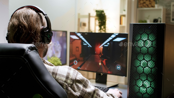 Over shoulder shot of man with long hair playing shooter games Stock ...
