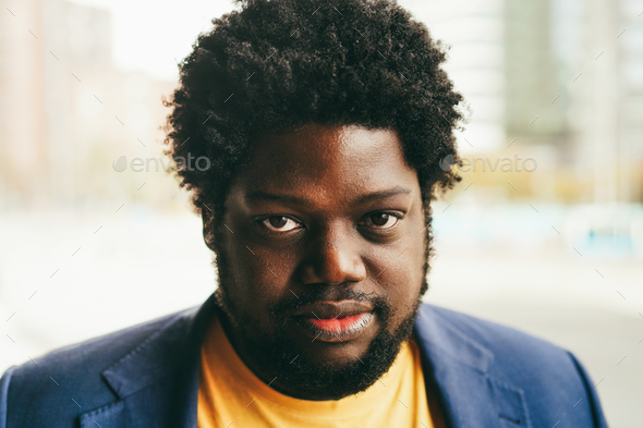 African plus size man looking at camera outdoor - Focus on face Stock ...