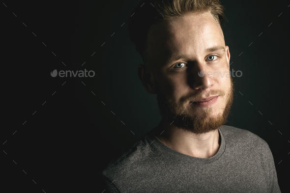 portrait of young man above black background Stock Photo by FabrikaPhoto