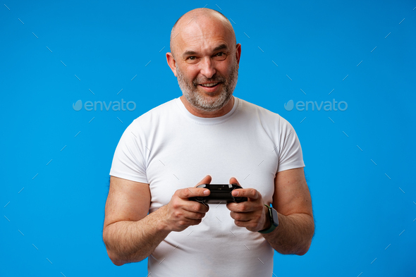 Portrait of middle-aged man playing videogames with joystick against ...