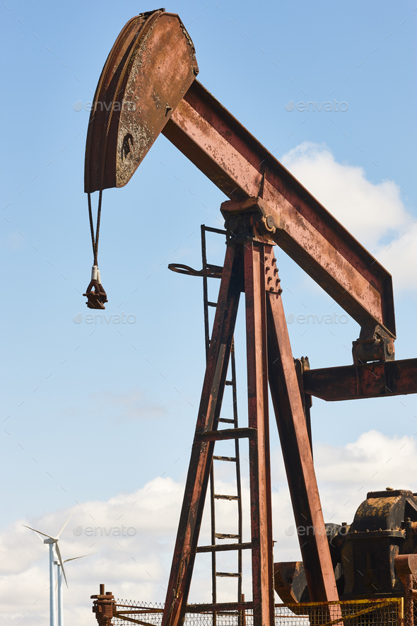 Oil pumping machine and windmills. Petroleum extraction. Resource Stock ...