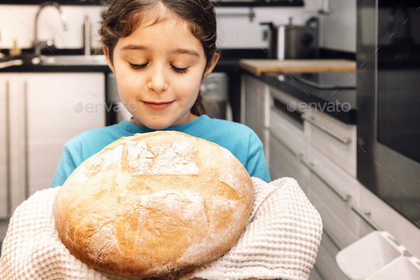child smelling freshly baked bread Stock Photo by Raul_Mellado | PhotoDune