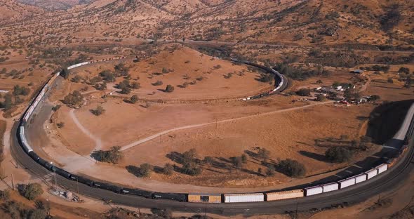 Aerial view of long freight train passing through Tehachapi Loop ...