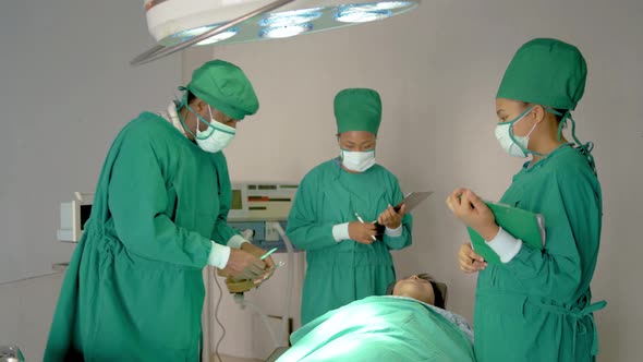 Professional surgeon teaching young medical interns performing organ ...