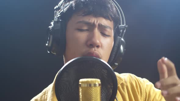 Young Asian Boy With Headphone Rapping Into A Condenser Microphone On ...