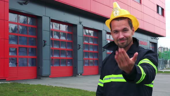 A Young Firefighter Smiles and Motions To the Camera in a Gesture of ...