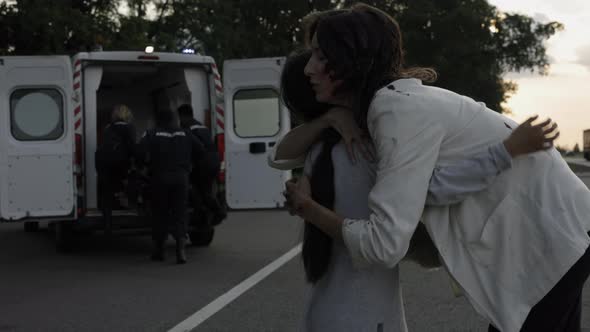 Mother Hugging Daughter While Paramedics Rescuing Father, Stock Footage
