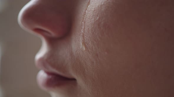 Close-up of a Woman's Cheek with a Tear Sliding Down It. A Tear Slowly ...