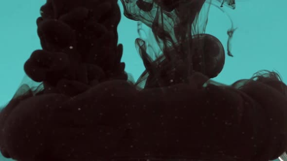 A Lot of Black Ink Flushing Into Clear Water Over Cyan Background in ...