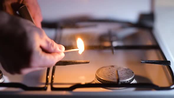Ignition of a gas stove, close-up. Igniting a match and igniting gas ...