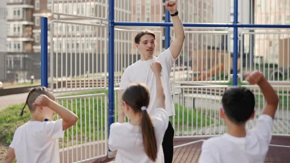 Caucasian Teacher and Group of Elementary Students Exercising During ...