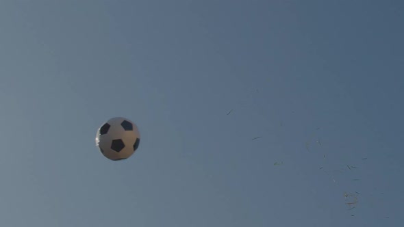 Slow motion wide shot of a soccer ball (football) flying through the ...